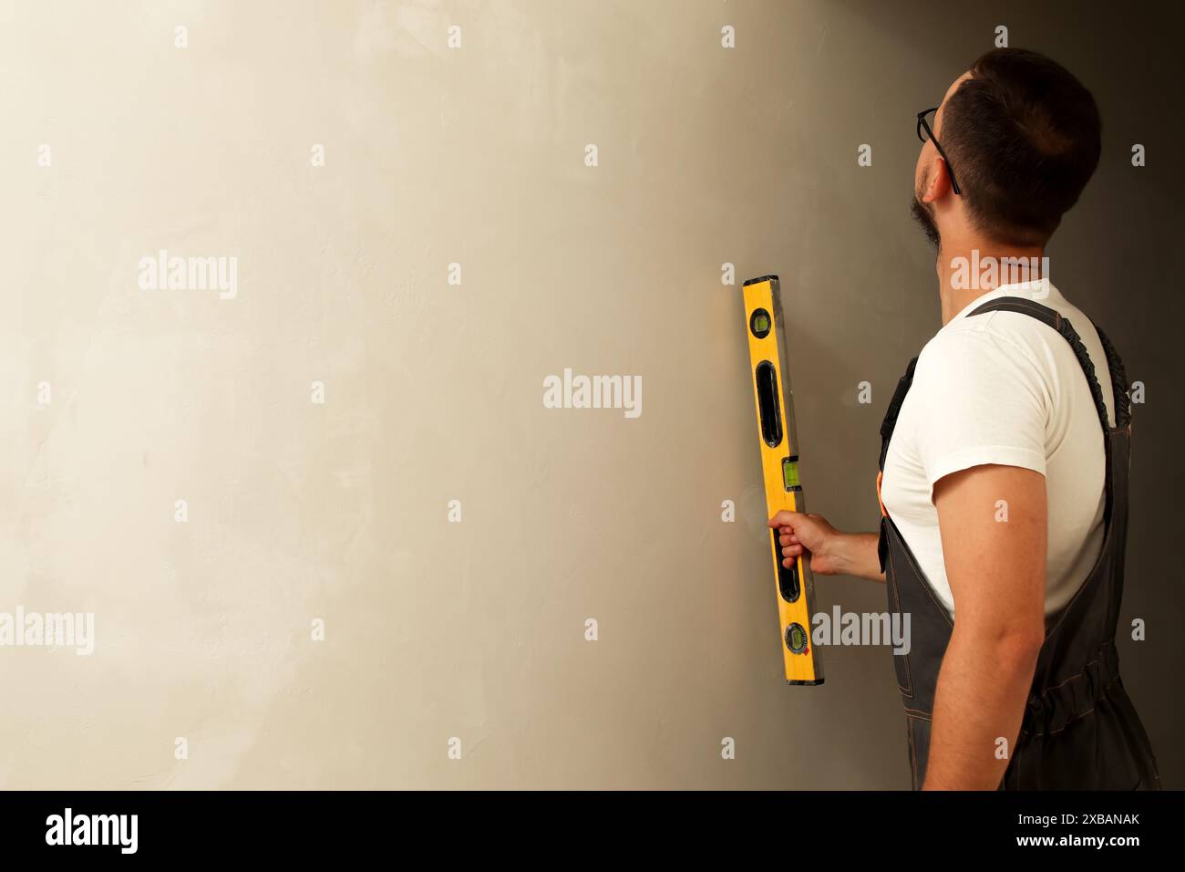 Professional using level tool on wall, clean background, excellent for ...