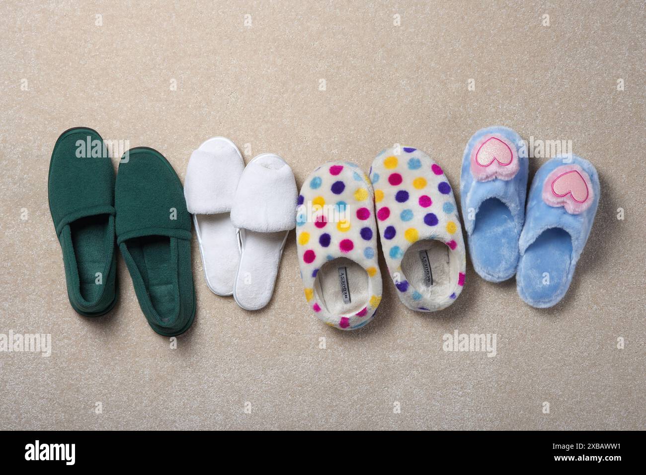 Slippers of various styles, colors, sizes and patterns lined up ...