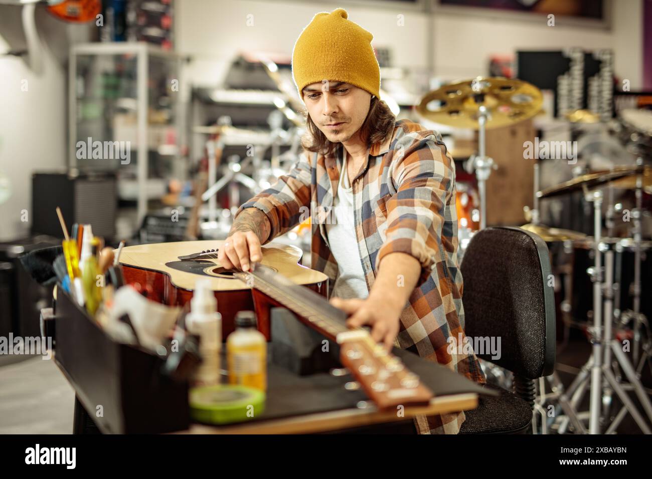 Guy repairing electric guitar in a music instrument workshop Stock ...