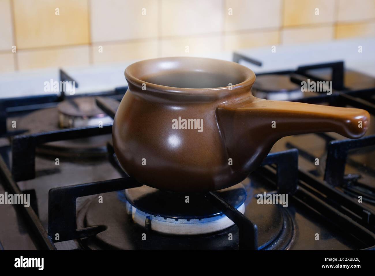 Brewing Turkish coffee in a ceramic Turk on a gas stove. Turkish coffee ...