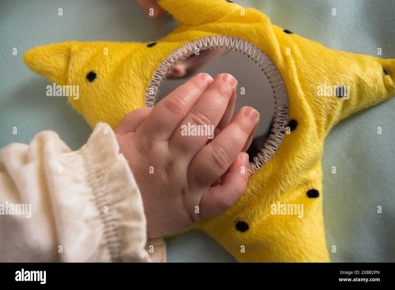 Baby girl hand holding yellow star toy Stock Photo - Alamy