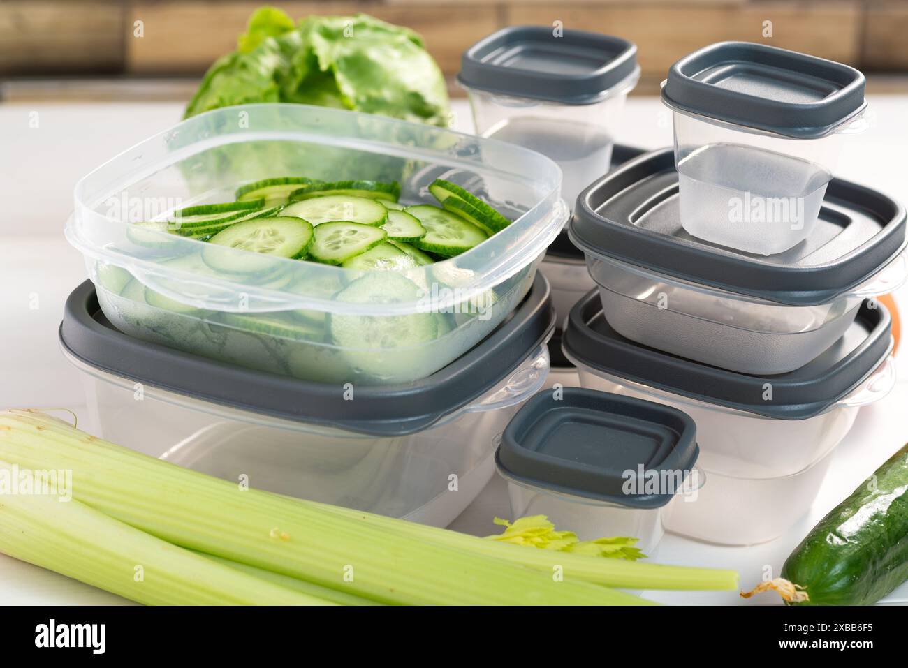 A stack of plastic containers and raw vegetables on the table. Storage ...