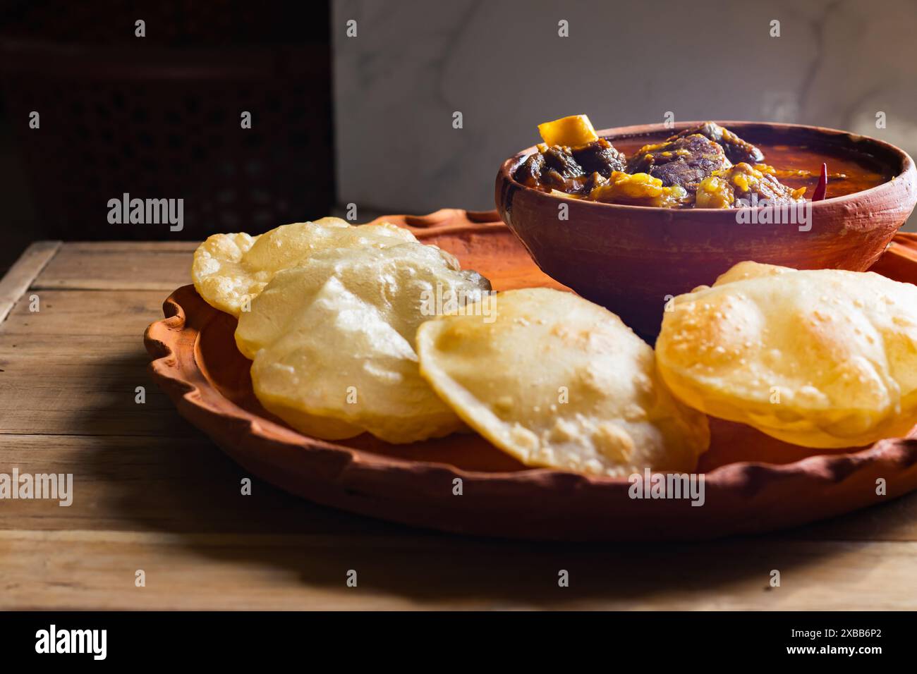 luchi or puri and mutton curry or laal maas served on earthen plate ...