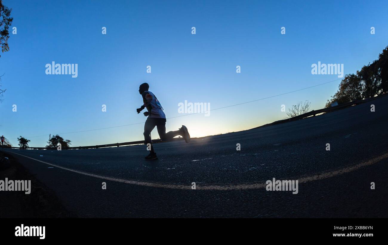 Marathon runners silhouetted morning dawn sunrise running up hill in ...
