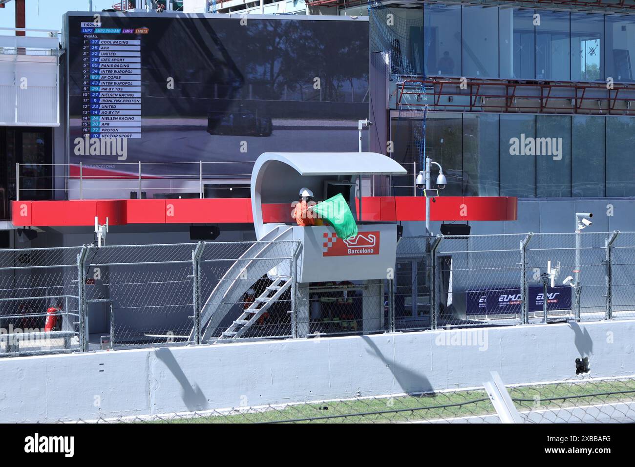 Green flag being waved by race Marshall at the 2024 Barcelona European ...