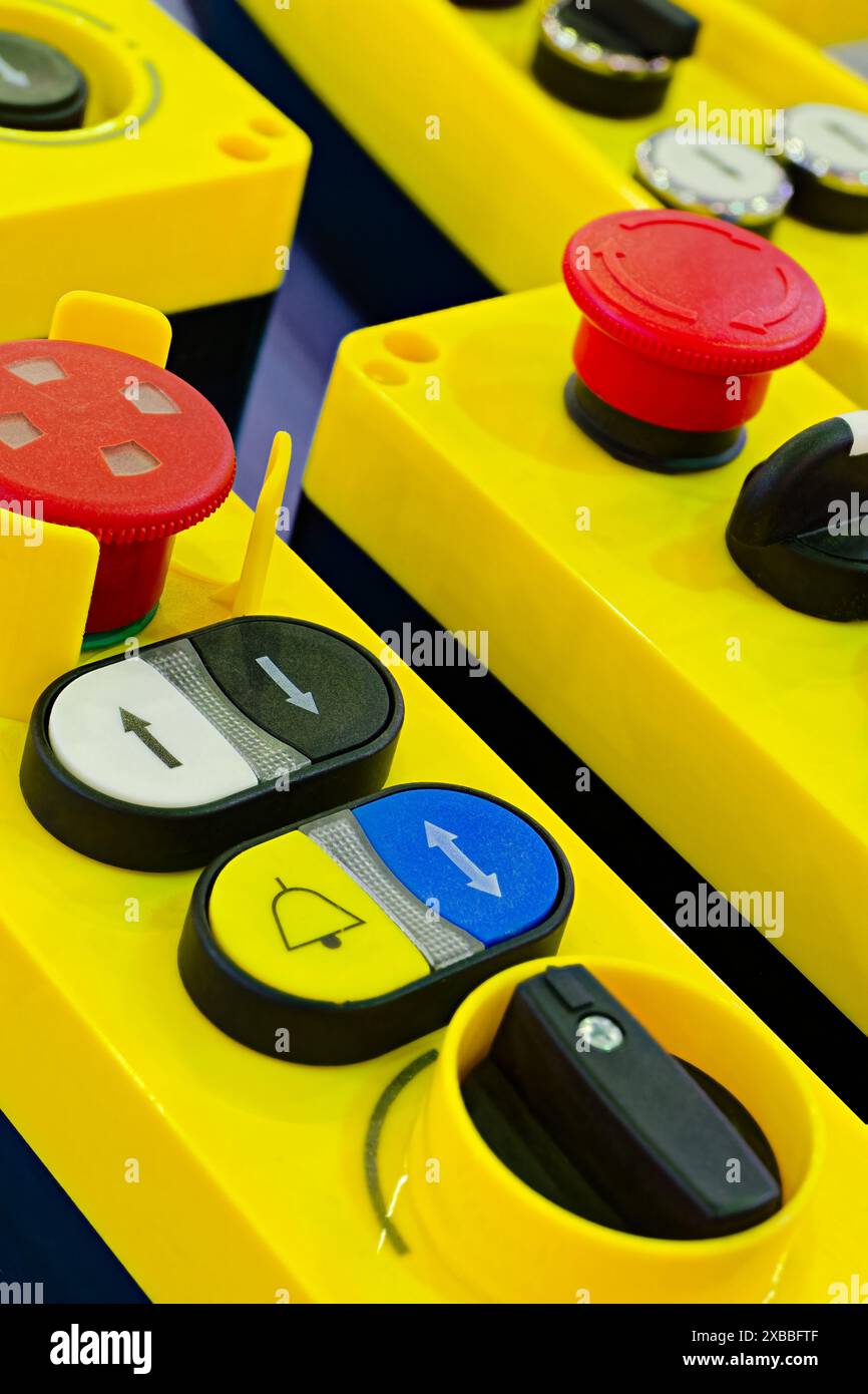 Assorted yellow plastic industrial remotes with buttons and switches ...