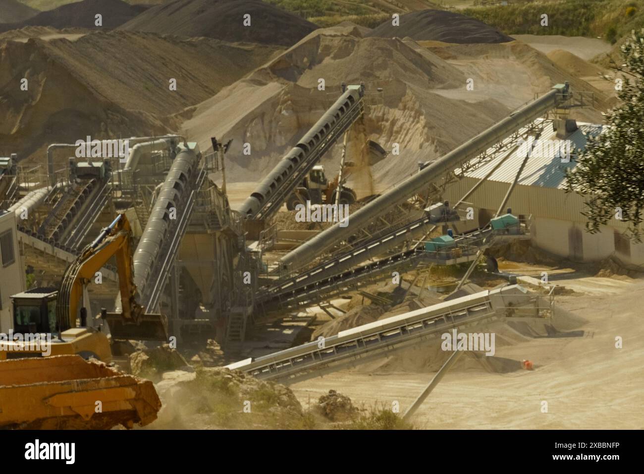 Heavy machinery operates in a quarry processing materials, with ...