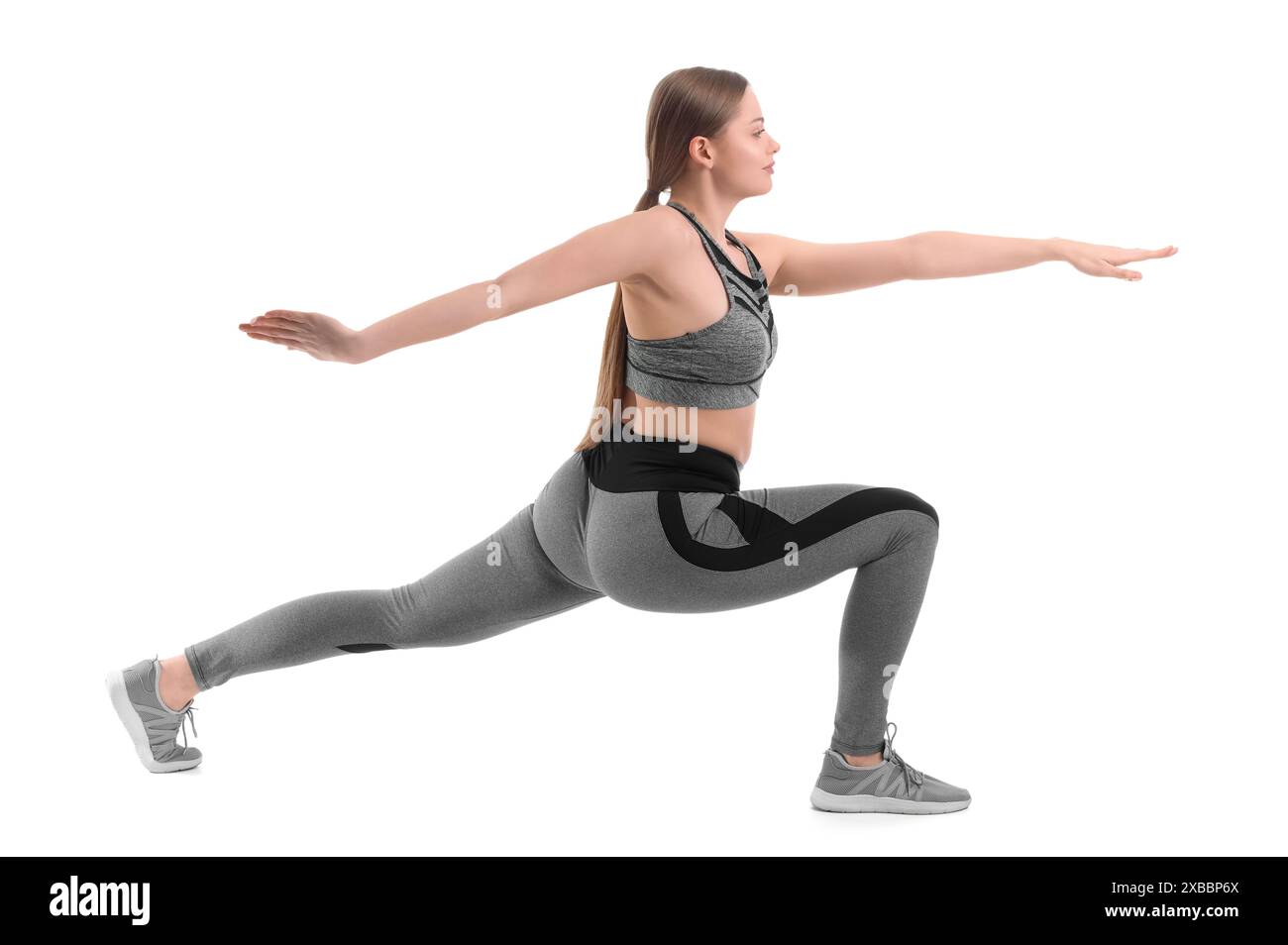 Sporty young woman balancing on white background Stock Photo - Alamy