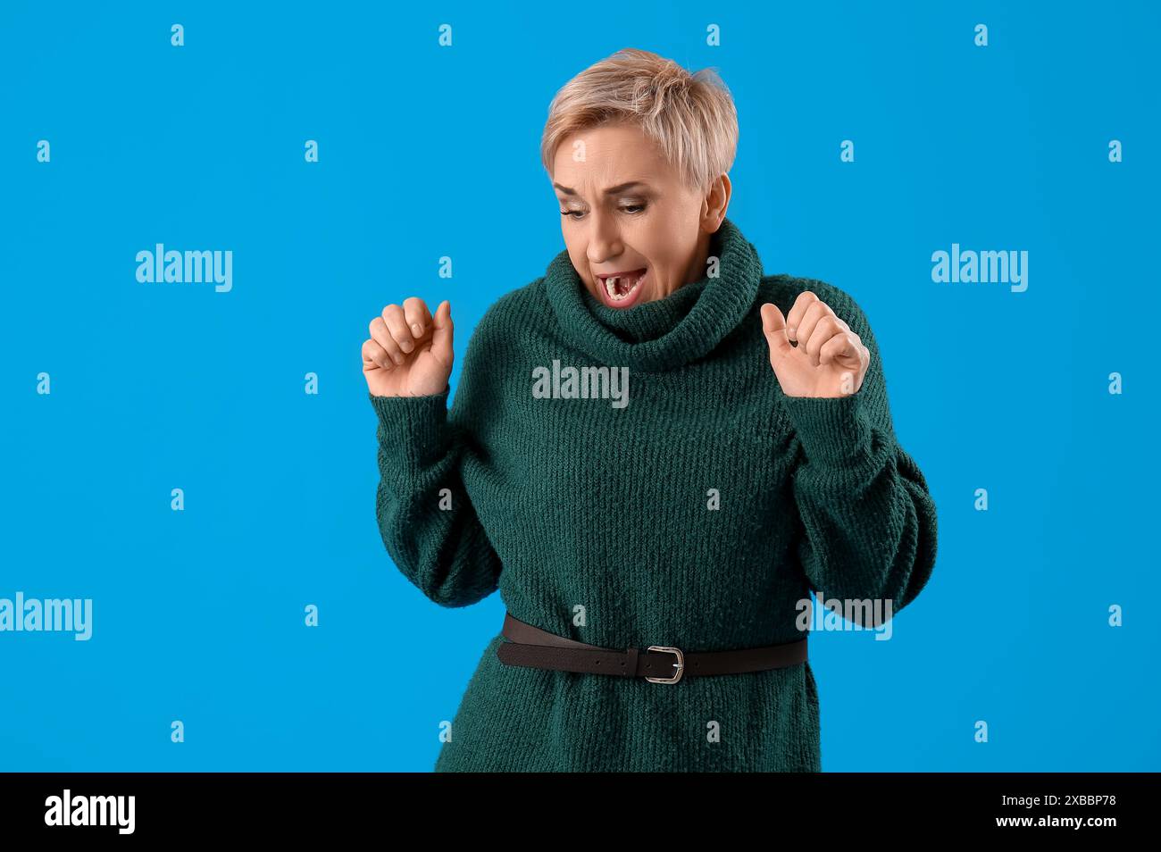 Scared mature woman on light blue background Stock Photo - Alamy