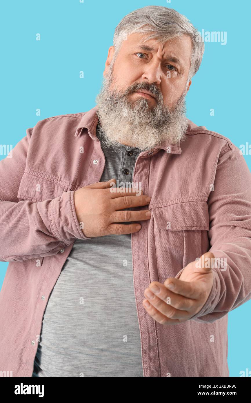 Portrait of sad senior man pleading on blue background Stock Photo - Alamy