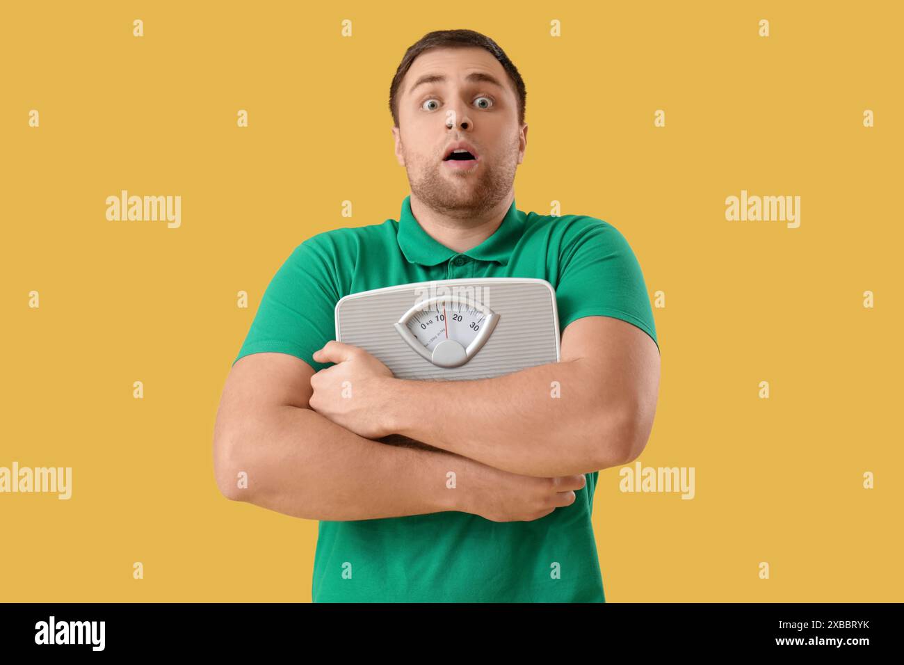 Shocked young man with scales on yellow background. Weight loss concept ...