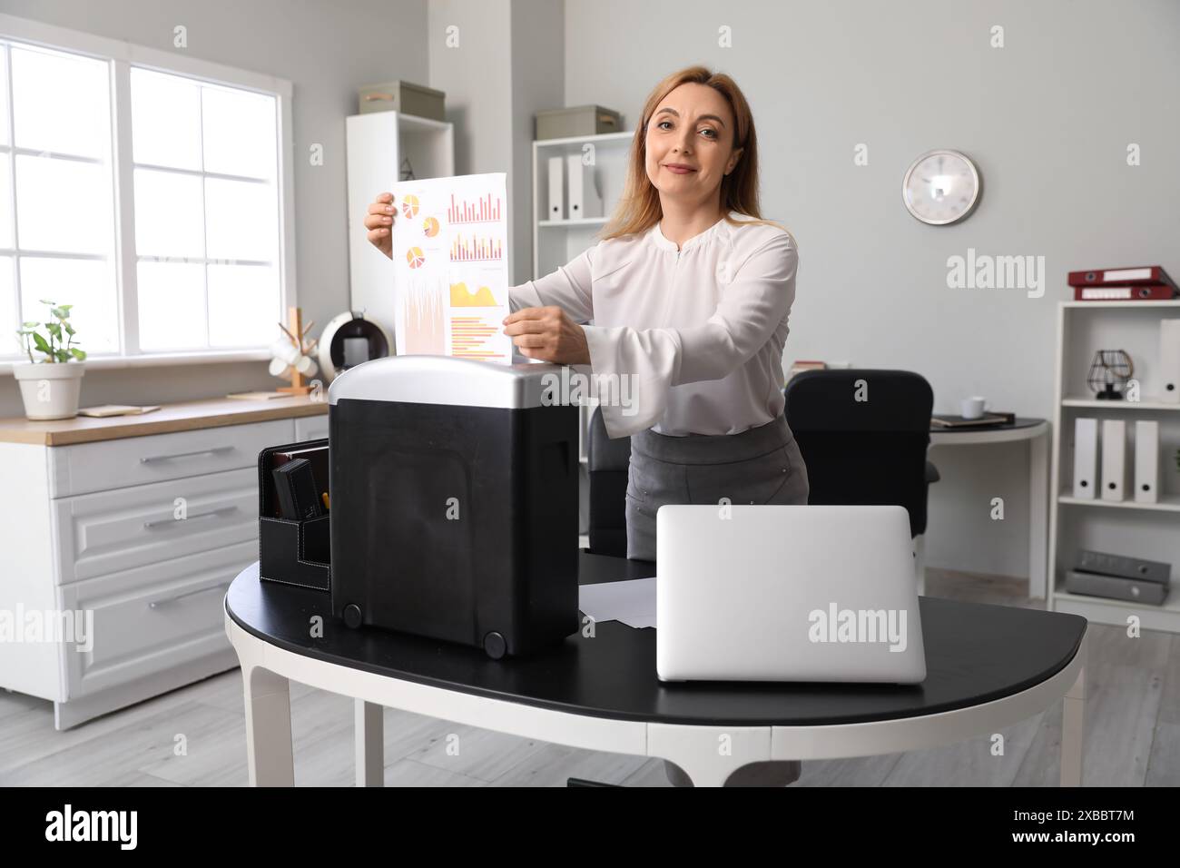 Adult secretary destroying documents using shredder in office Stock ...