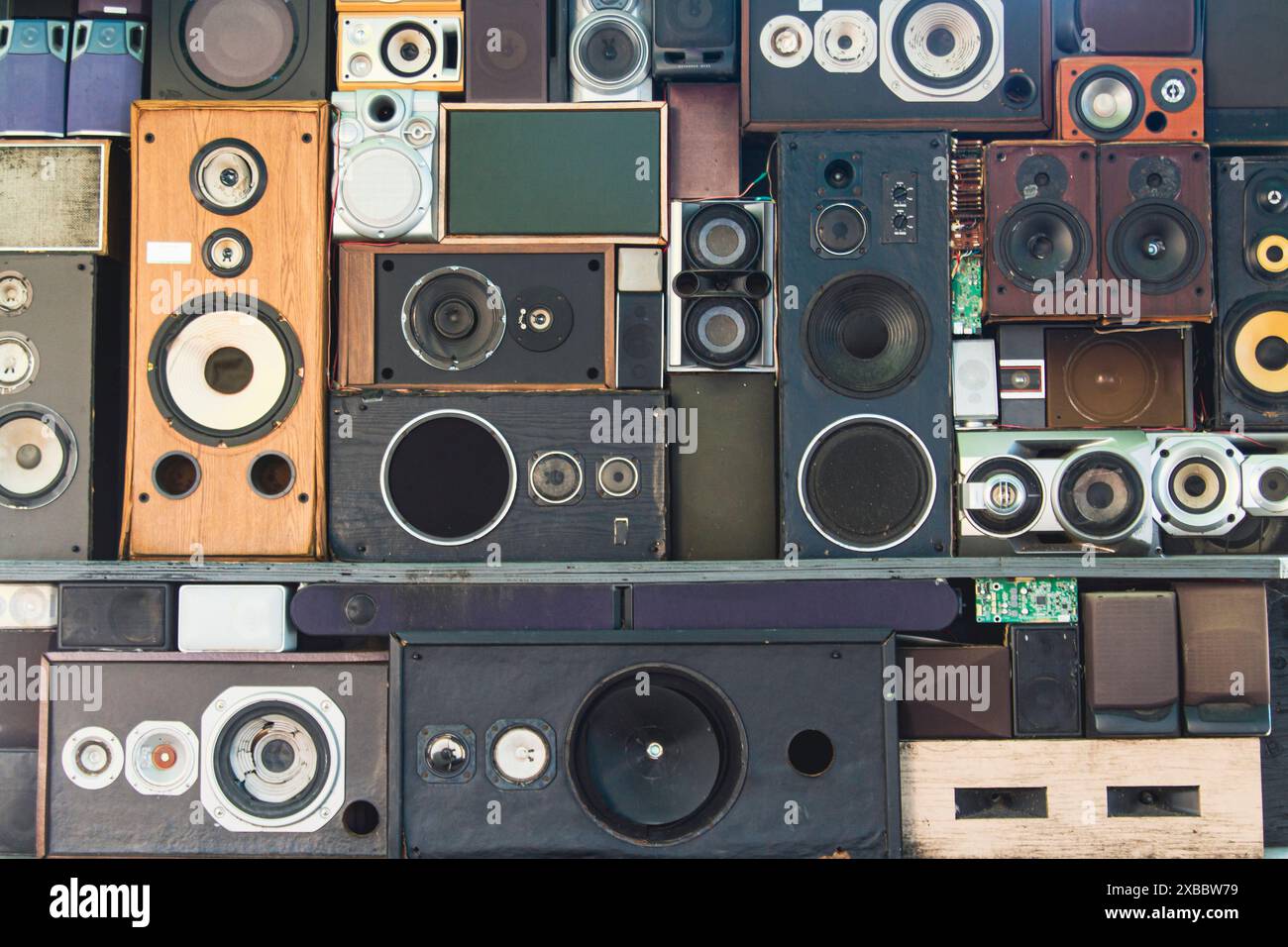 Wall of various old, colorful stereo speakers stacked on top of each ...