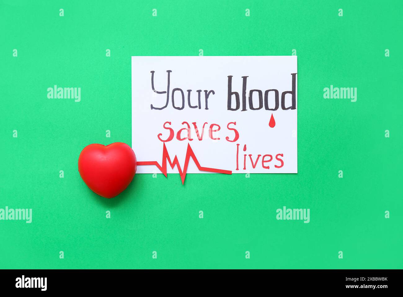 Paper sheet with text YOUR BLOOD SAVES LIVES, heart and cardiogram on ...