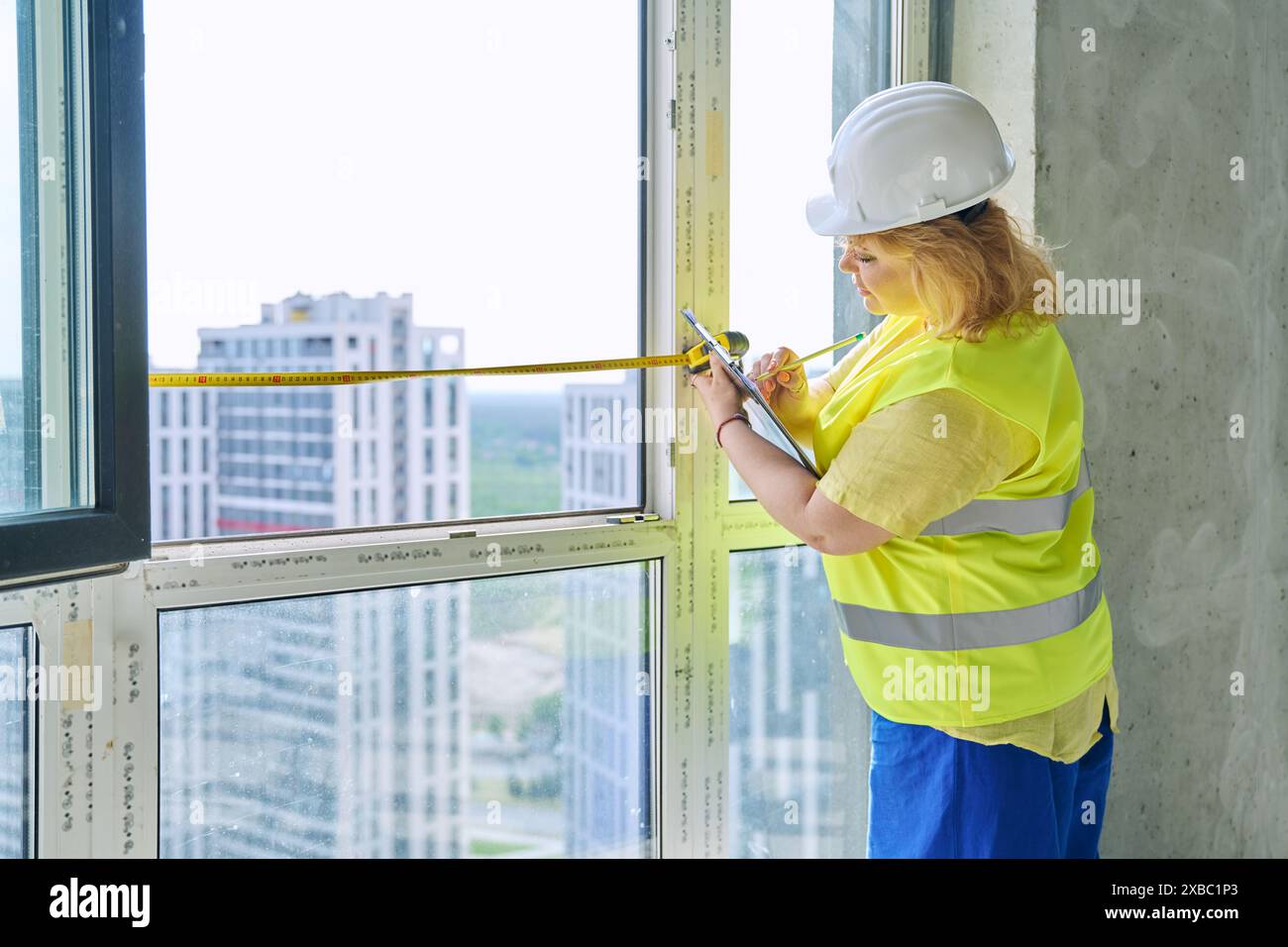 Female window decorator designer measuring window with tape measure ...