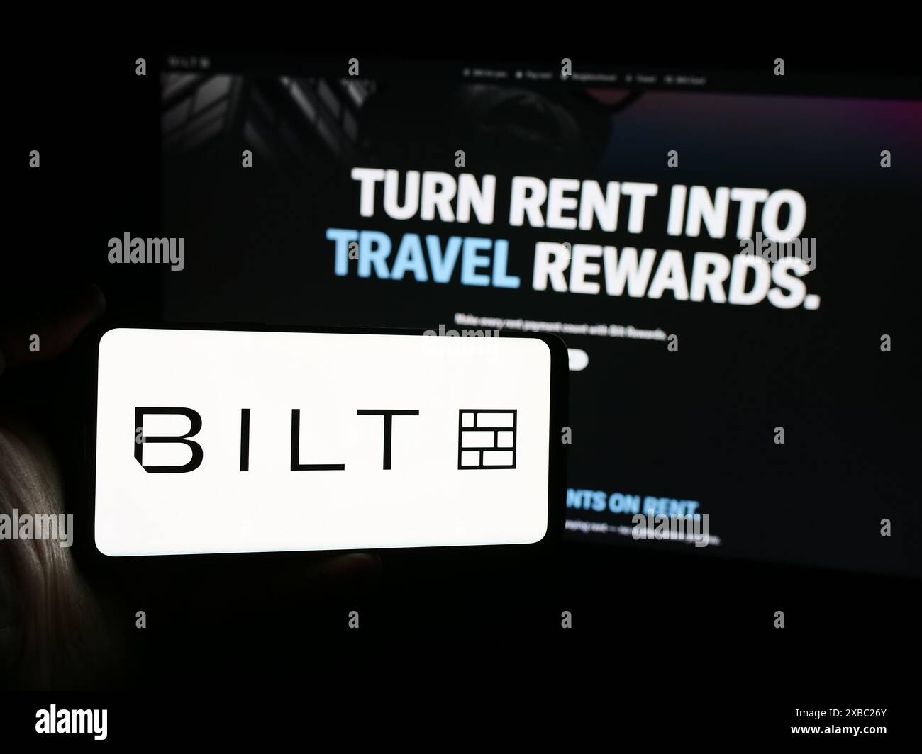 Person holding mobile phone with logo of American rental rewards company Bilt Technologies Inc ...
