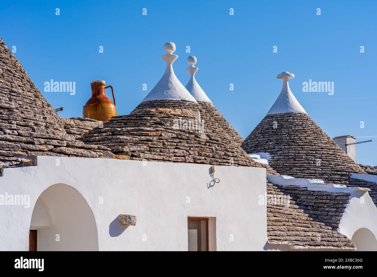 Conical roofs of the famous old dry stone trulli houses in Alberobello ...