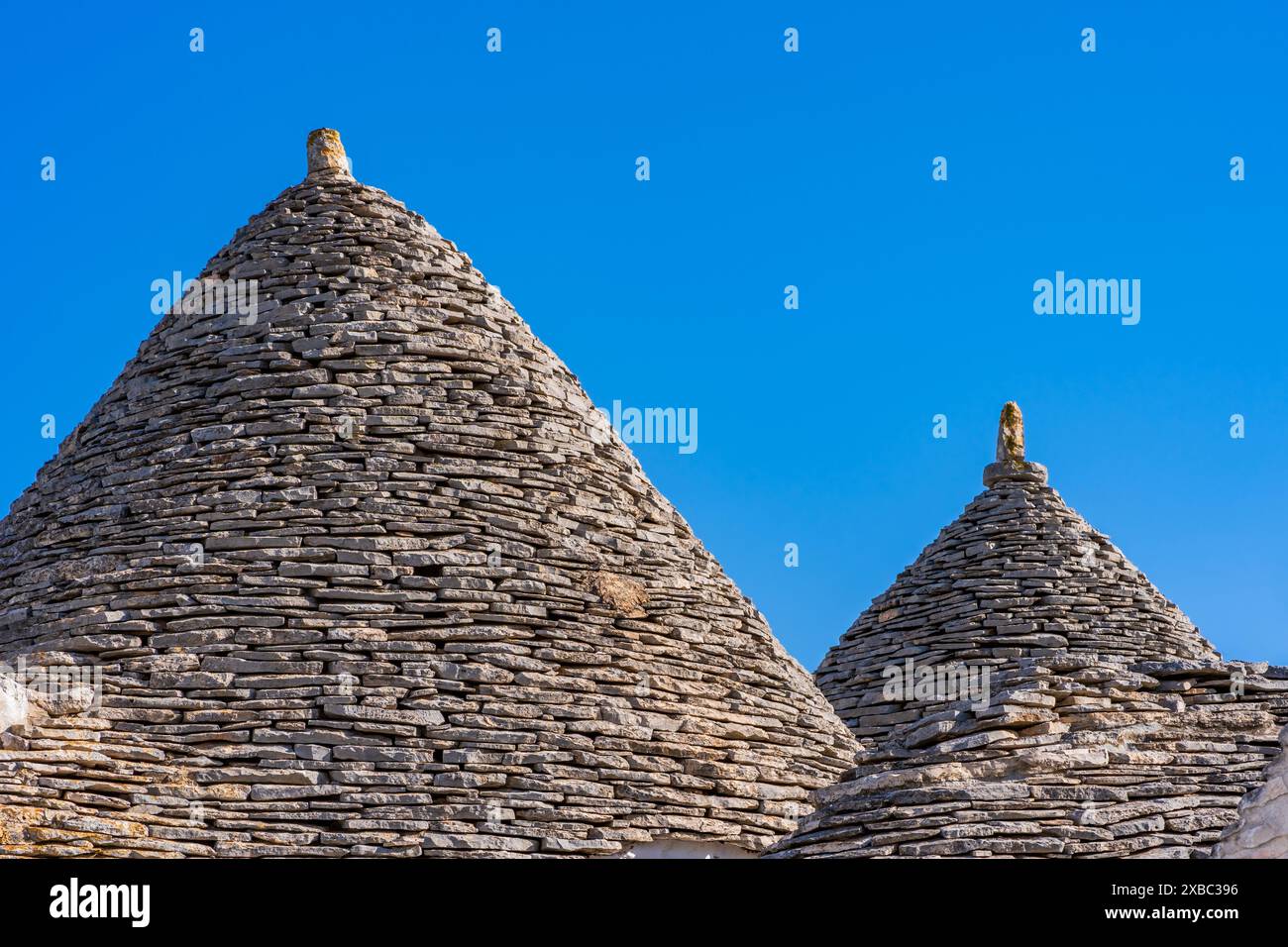Conical roofs of the famous old dry stone trulli houses in Alberobello ...