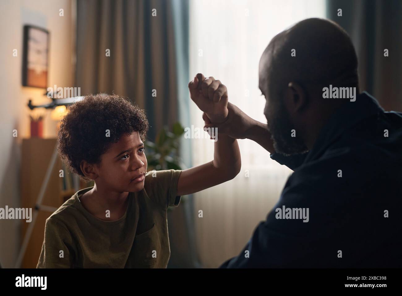Close up of father and son fighting with dramatic lighting copy space ...
