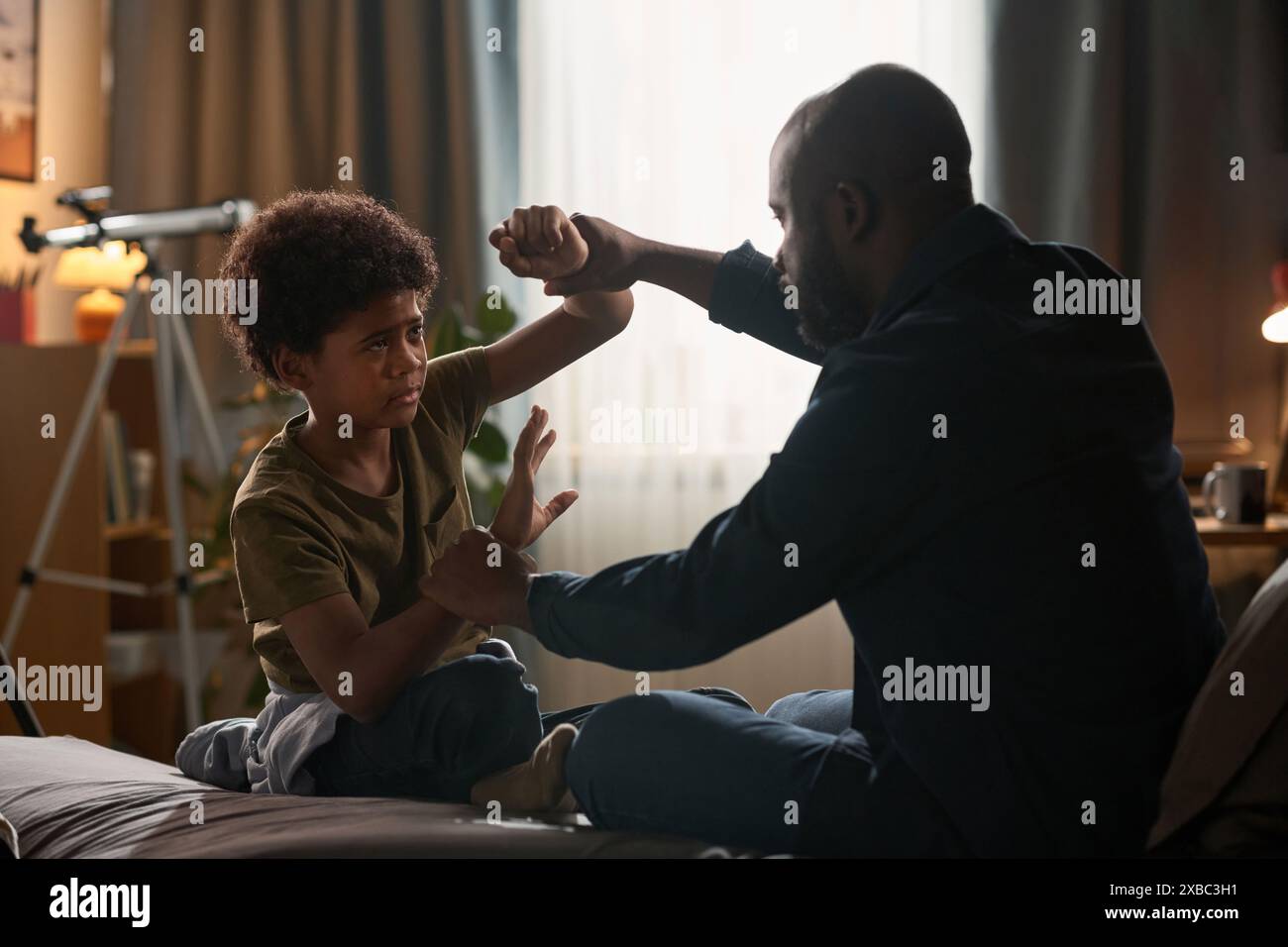 Side view portrait of father and son fighting aggressively sitting on ...
