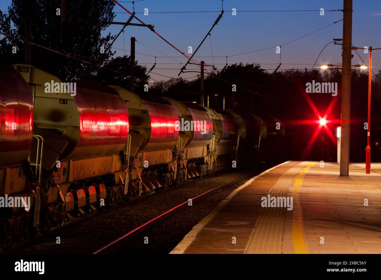 Network Rail auto ballaster wagons with a red railway signal in a ...