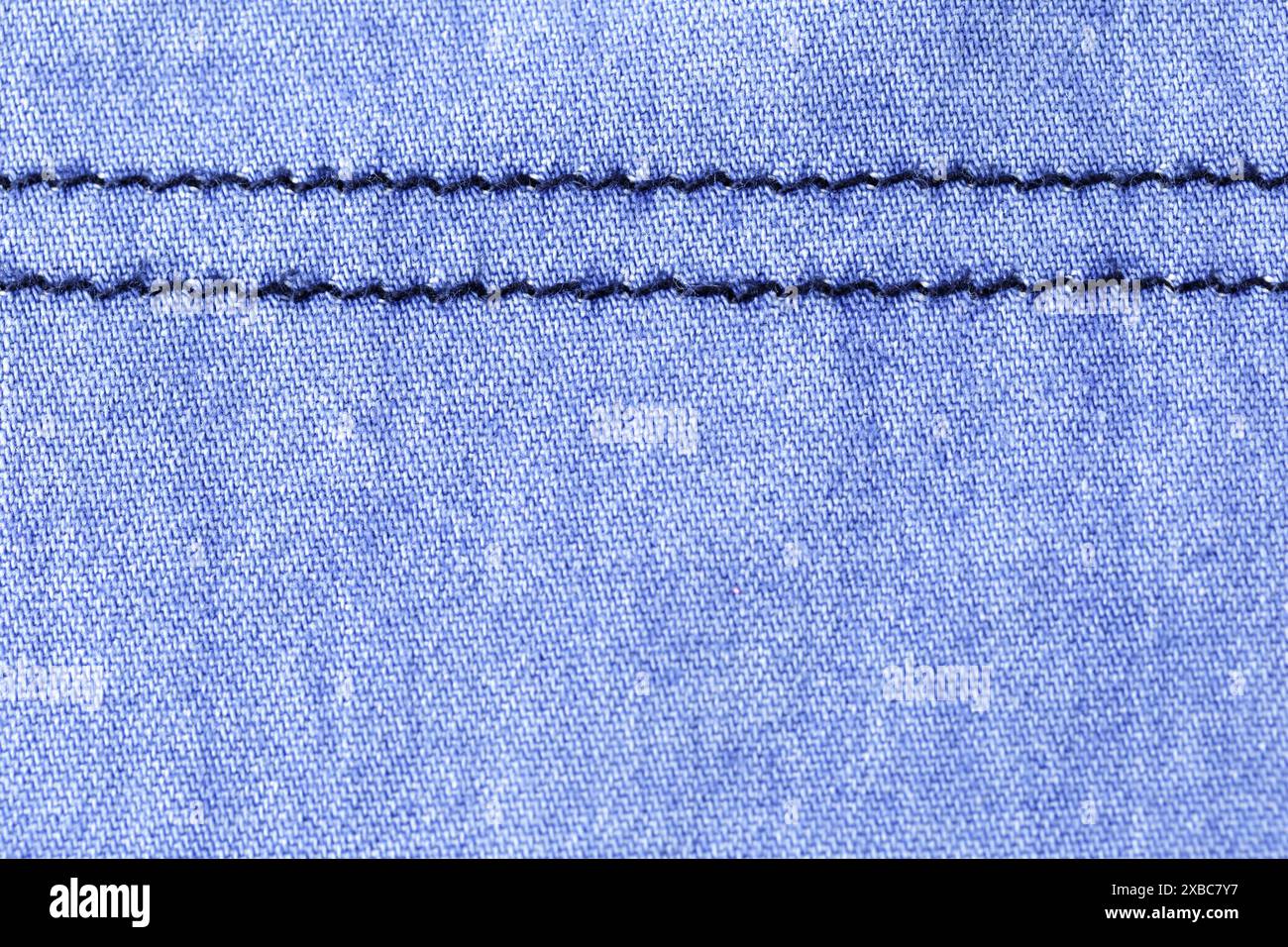 Detail of a blue fabric with a square print. The fabric has two ...
