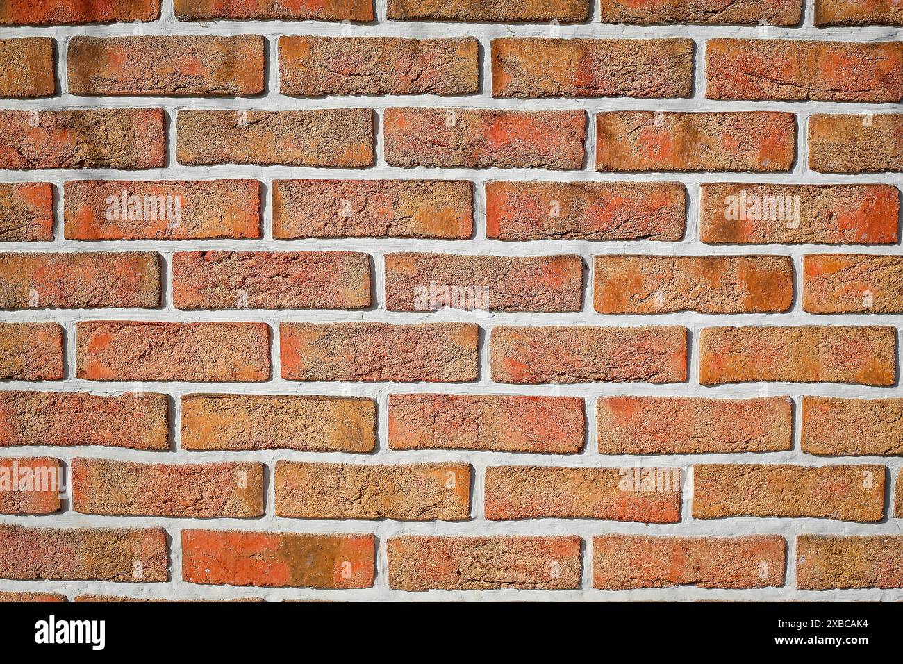 Weathered red brick wall with visible grout lines arranged in a ...