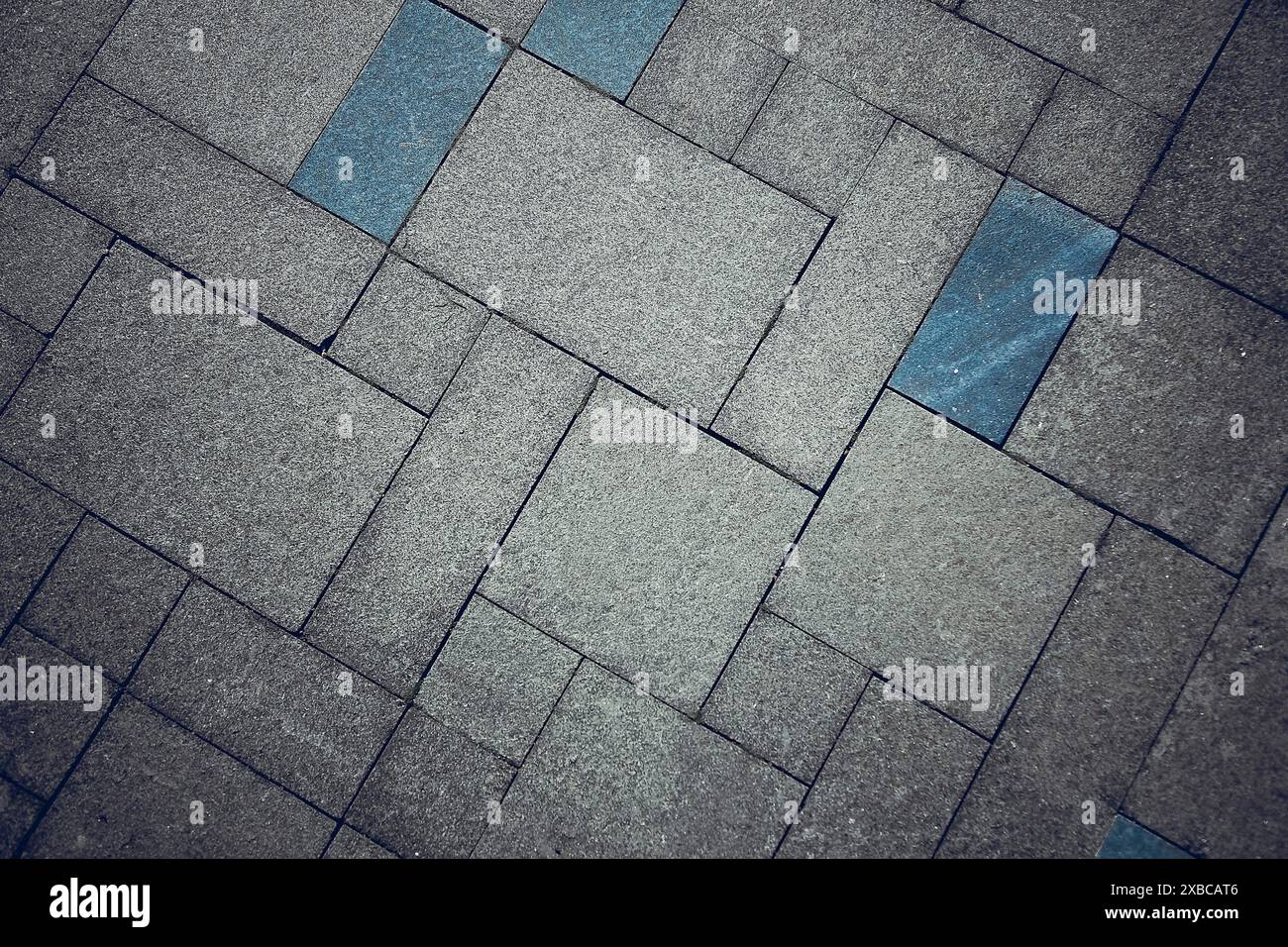 Close-up of a pavement with interlocking gray and blue tiles forming a ...
