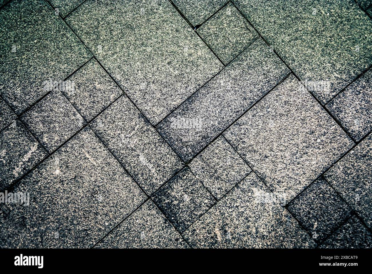 Gray concrete tiles arranged in a geometric pattern creating a rough ...