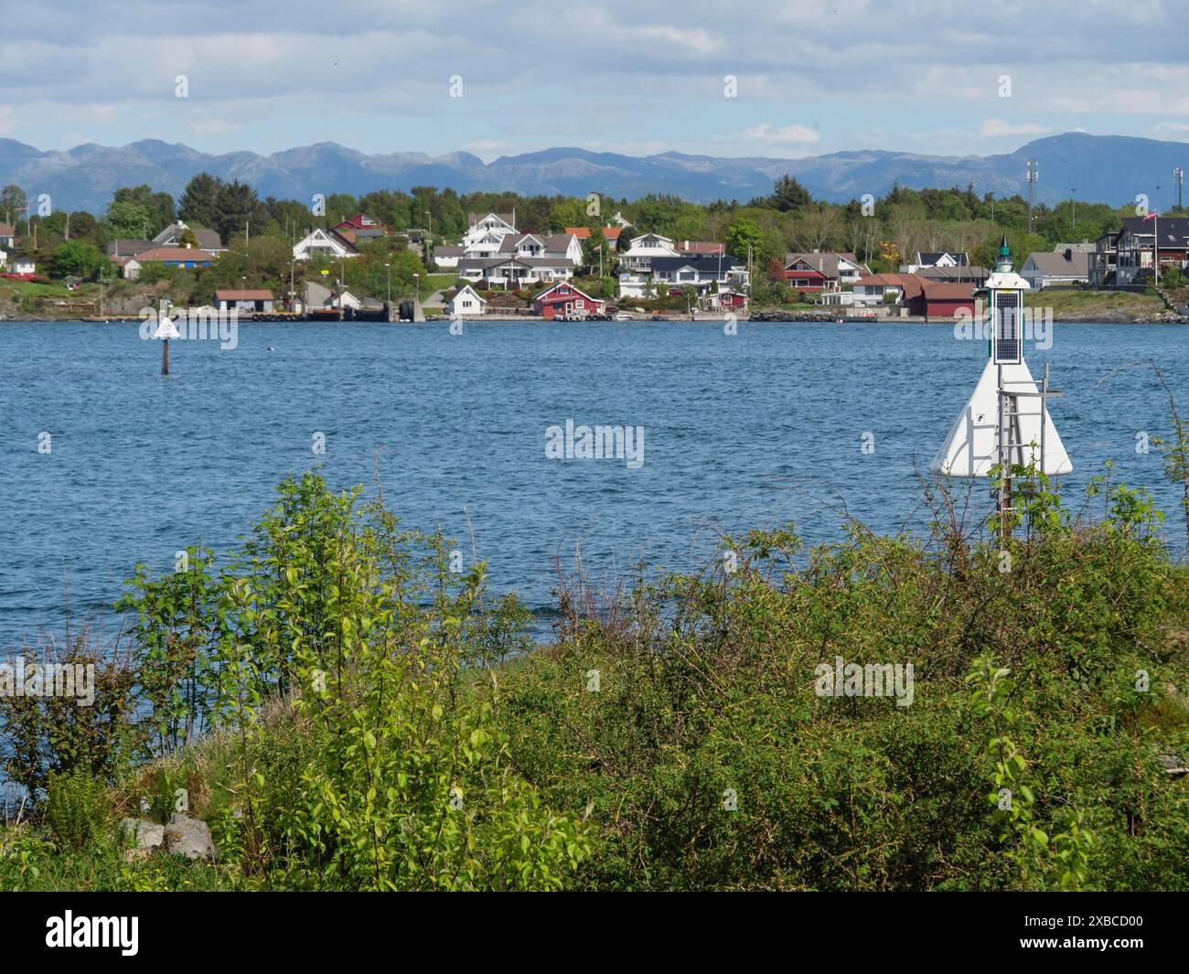 Coastal landscape with houses, sea view and mountains under a slightly ...