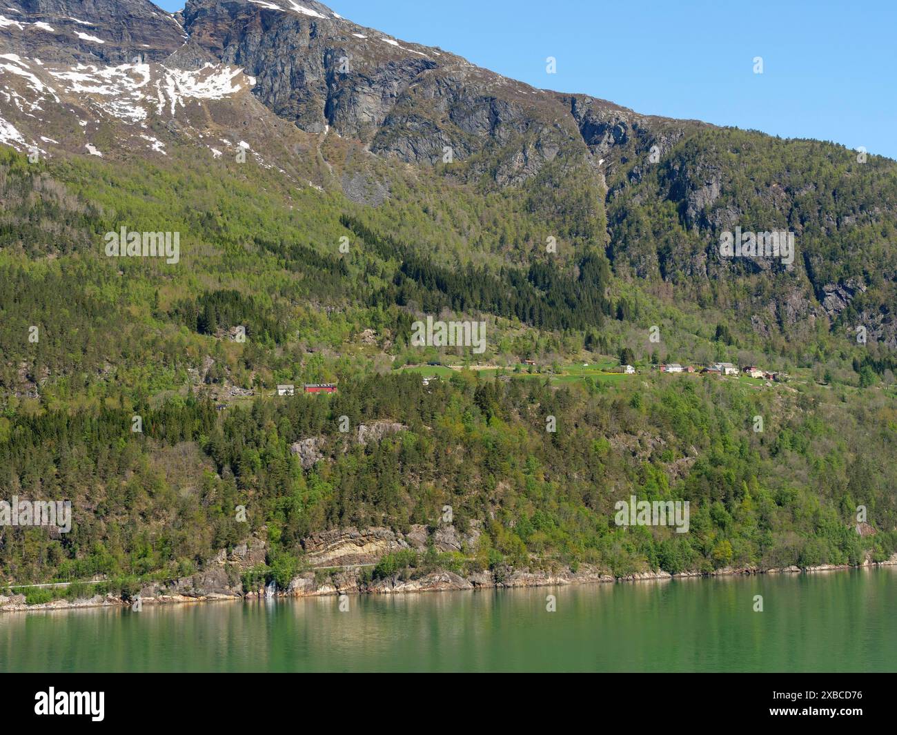 A residential area with scattered houses in the green mountains along a ...