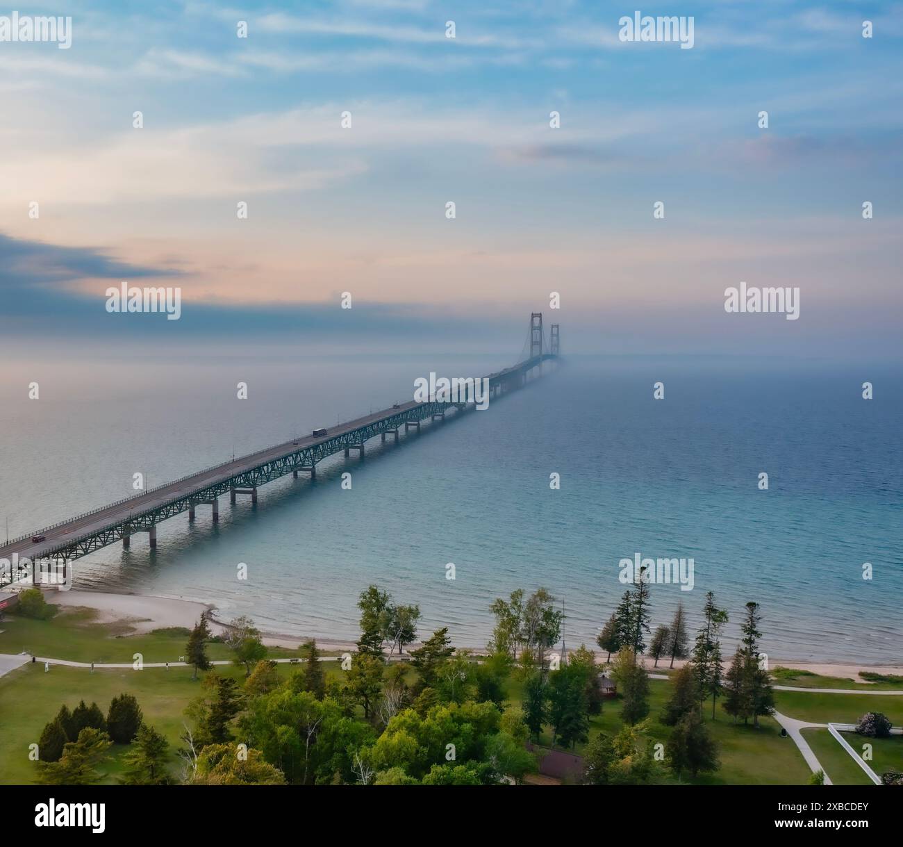 Aerial view of the Mackinac Bridge spanning over the foggy waters of ...