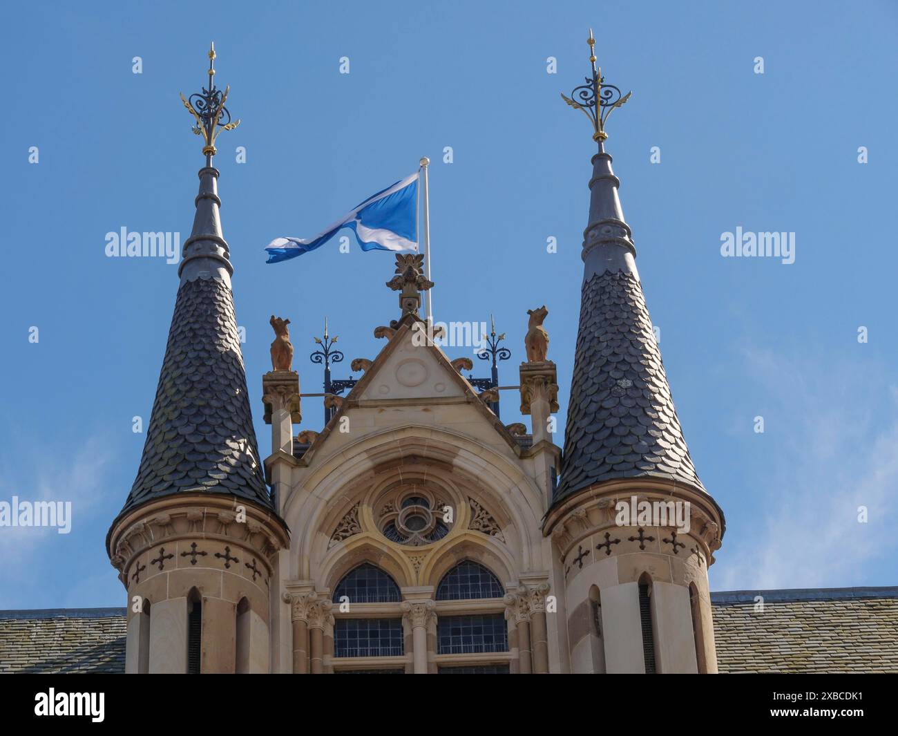 Gothic towers of a historic building with a blue flag under a bright ...