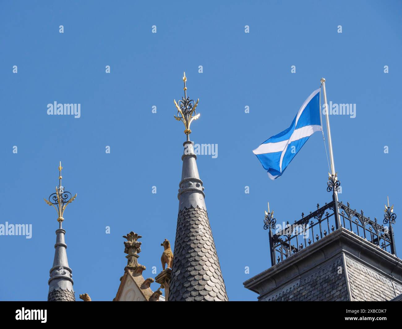 Towers of a gothic style building with a waving blue and white flag ...