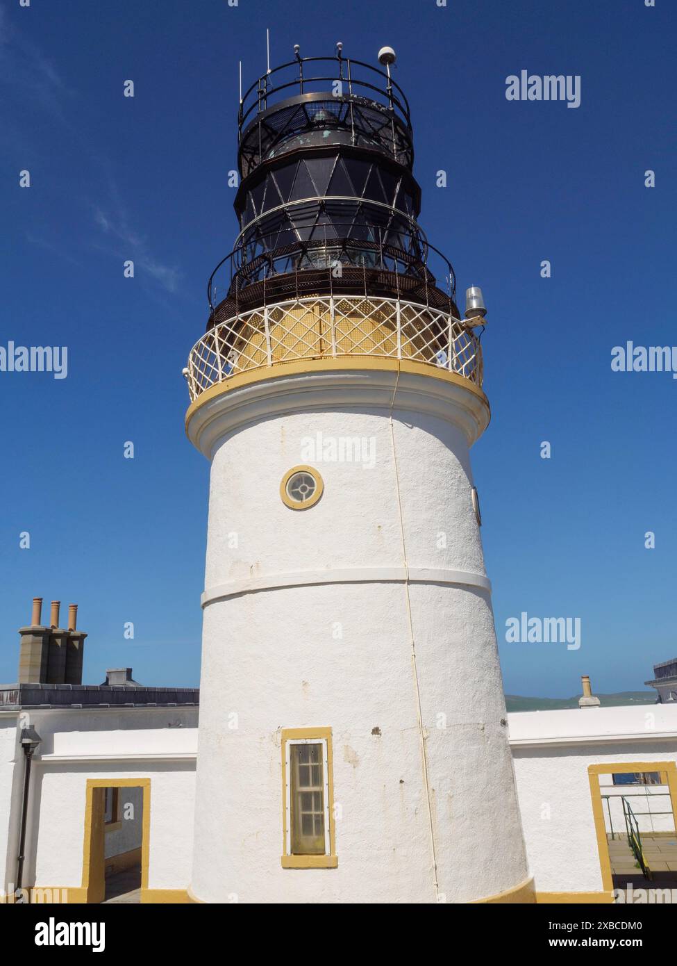White lighthouse with yellow accents under a clear blue sky, lerwick ...