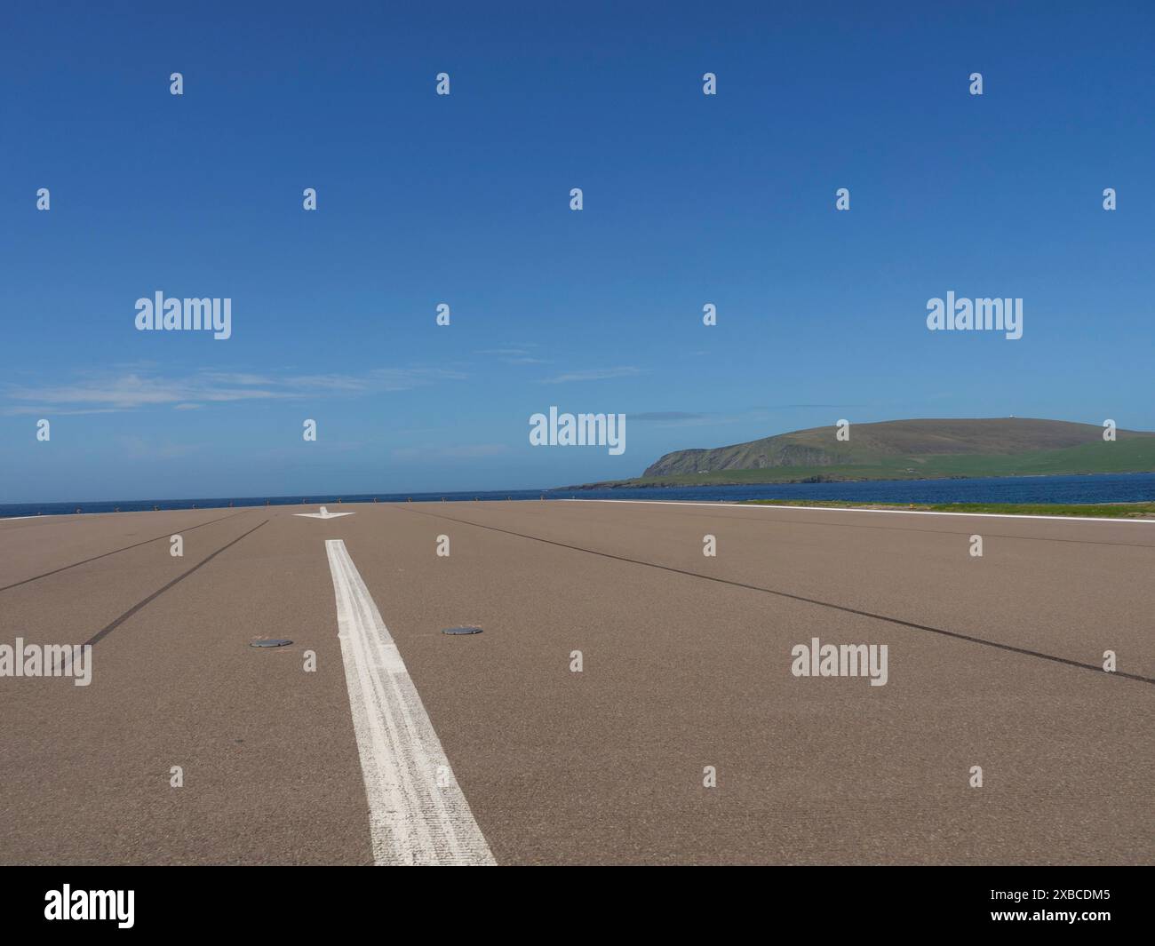 Runway on an island with a view of blue sky and sea to the horizon ...