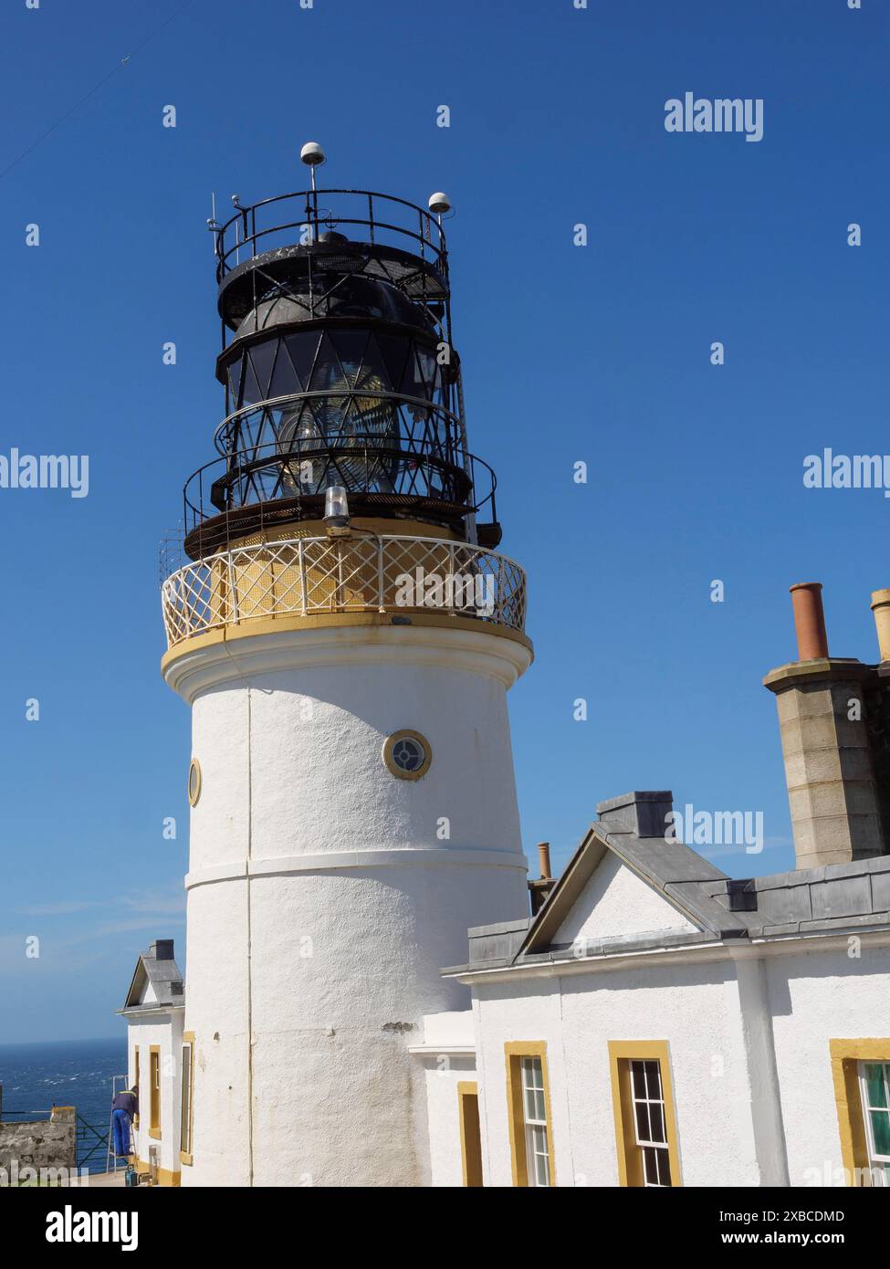 Bright lighthouse with yellow and white colour accents under a bright ...