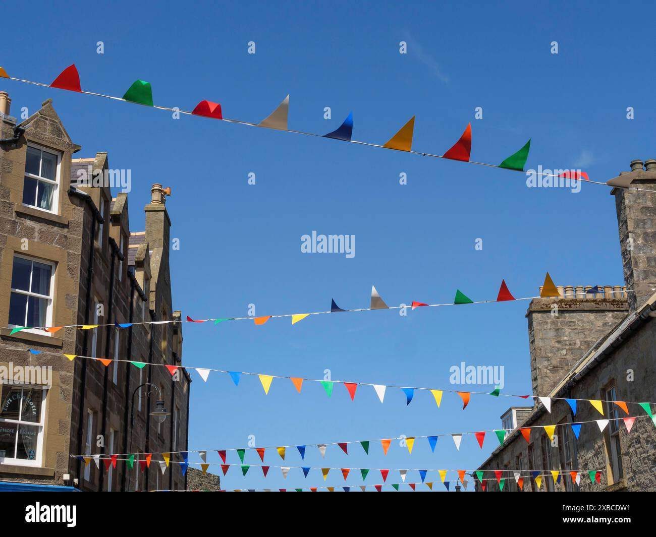 Simple houses decorated with colourful flags under a blue sky, lerwick ...