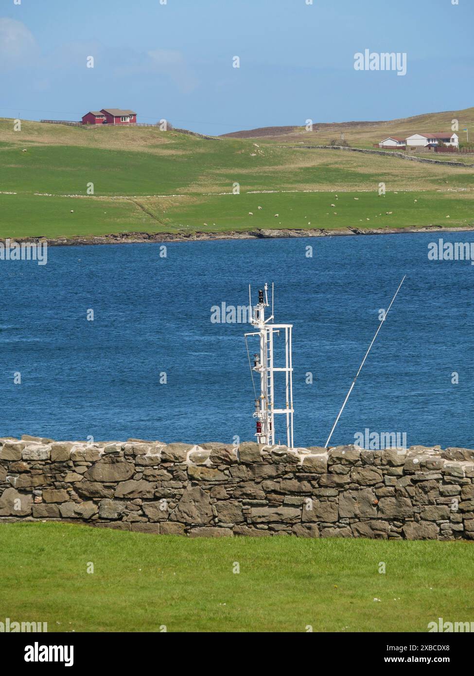 Coastal landscape with a lighthouse, green meadows, a red house and a ...