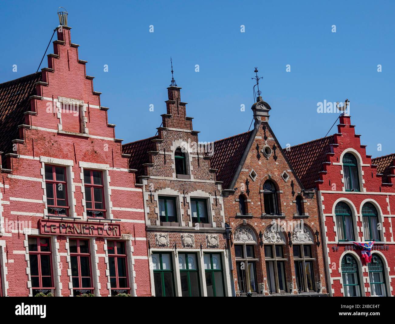 Historic brick buildings with different gables and dormers under a blue ...