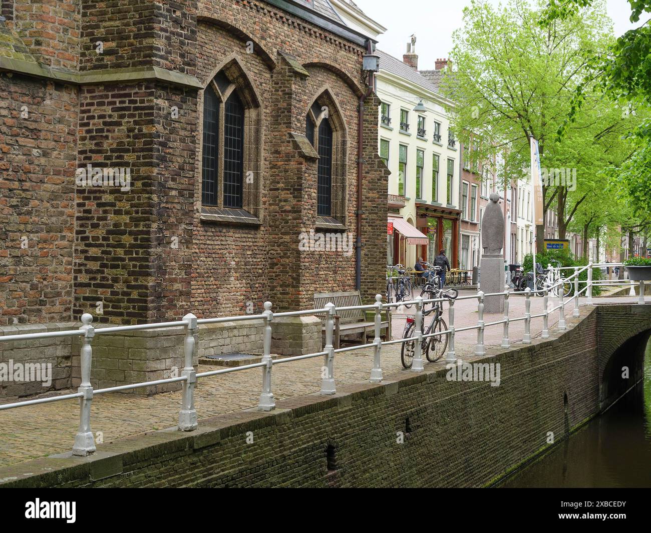 Church building next to a canal with cyclists and walkers along the ...