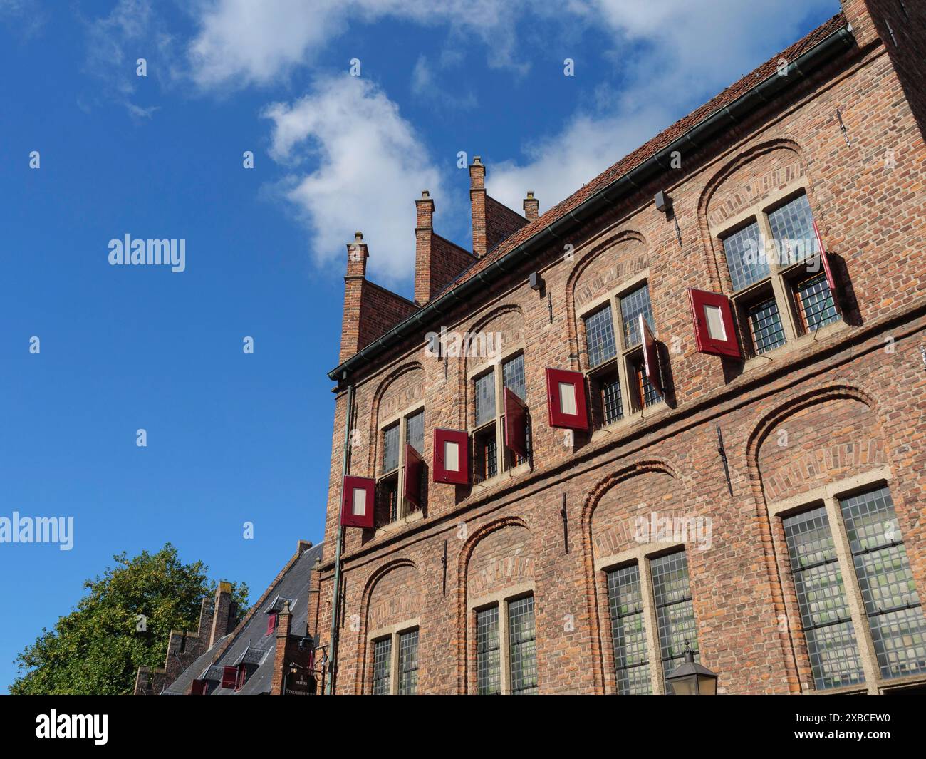 Historic building with red shutters and detailed brick patterns against ...