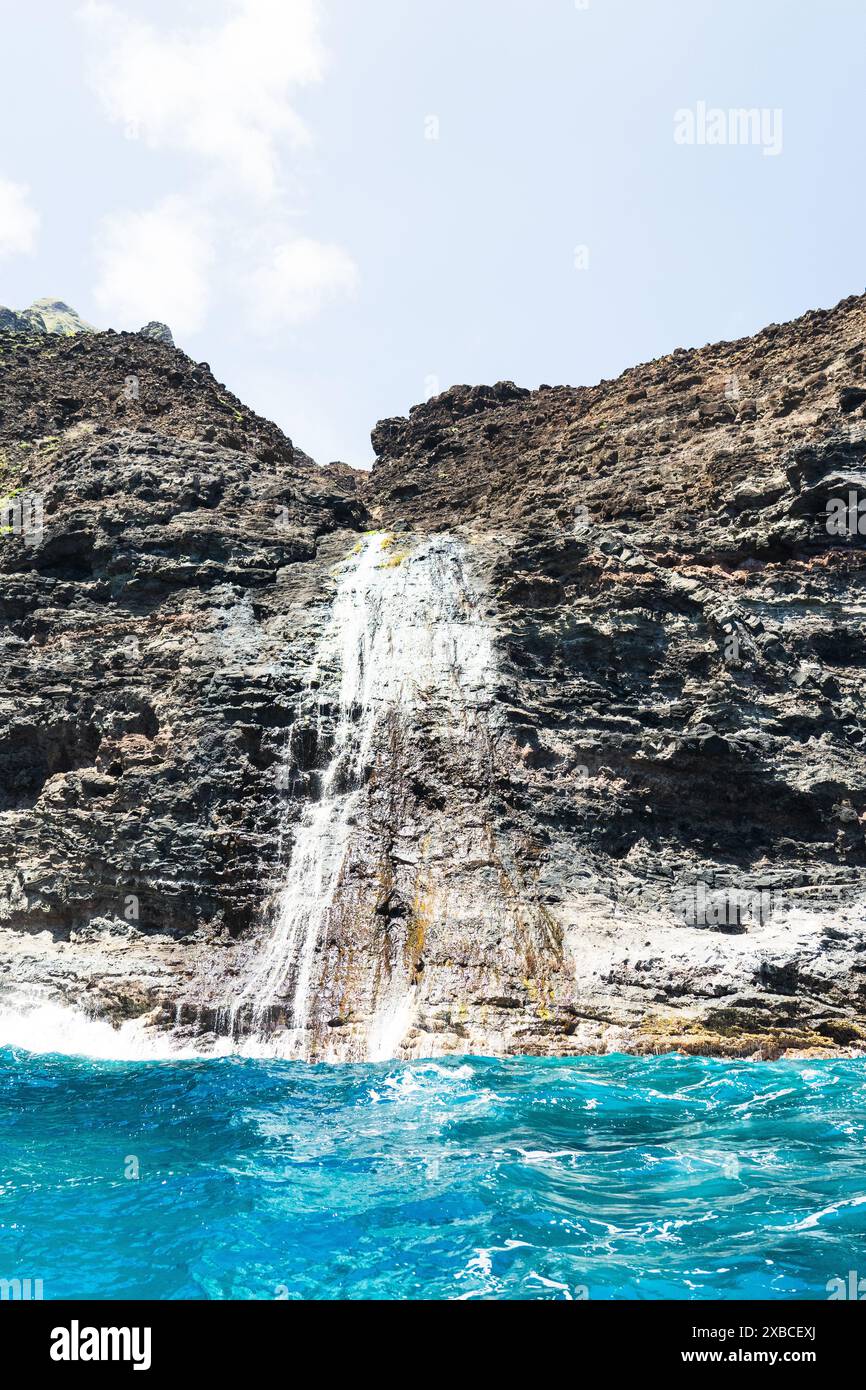 A stunning waterfall cascading down a rocky cliff into a vibrant blue ...