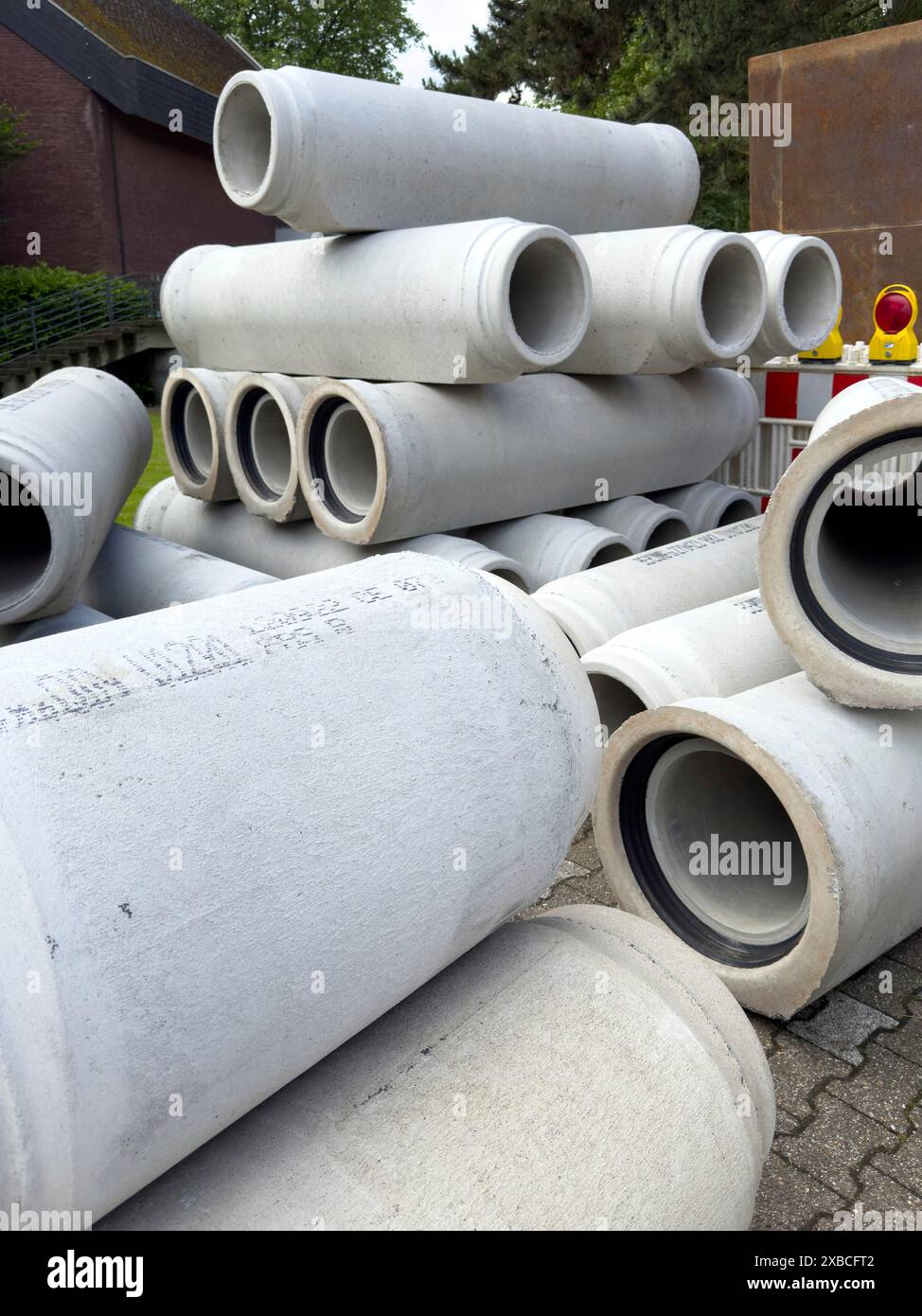 Several many stacked concrete pipes stored at the roadside Concrete ...