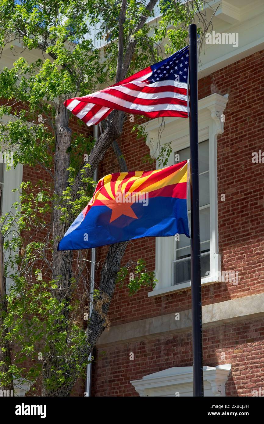 American flag, Arizona state flag waving on pole before brick victorian ...