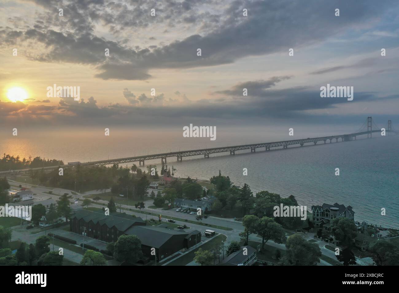 Aerial view of Mackinac Bridge at sunrise with a cloudy sky and calm ...