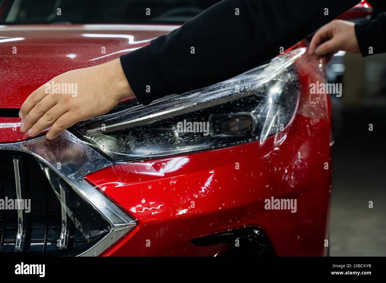 The process of applying protective vinyl film to car headlights in ...