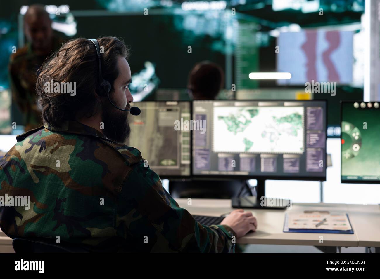 Military staff monitoring real time battlefield operation from CCTV radar system in command ...