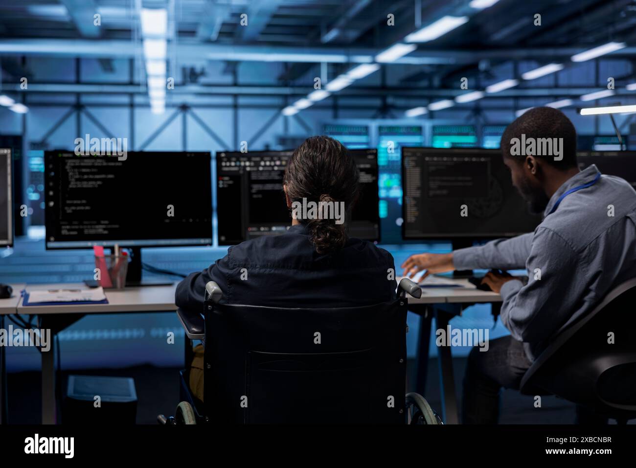 Person with paraplegia working in inclusive workplace typing data on PC ...