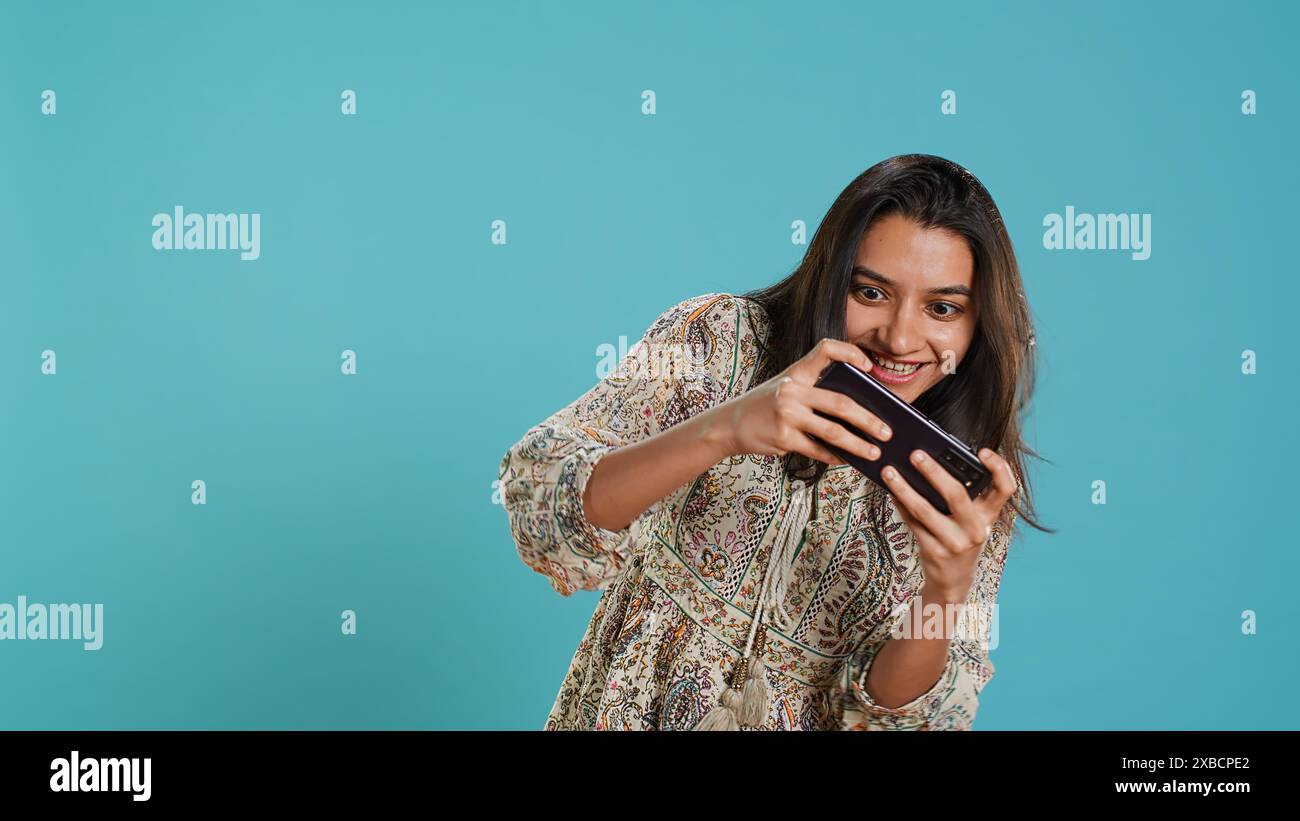 Delighted person playing intense mobile game, celebrating win, studio ...